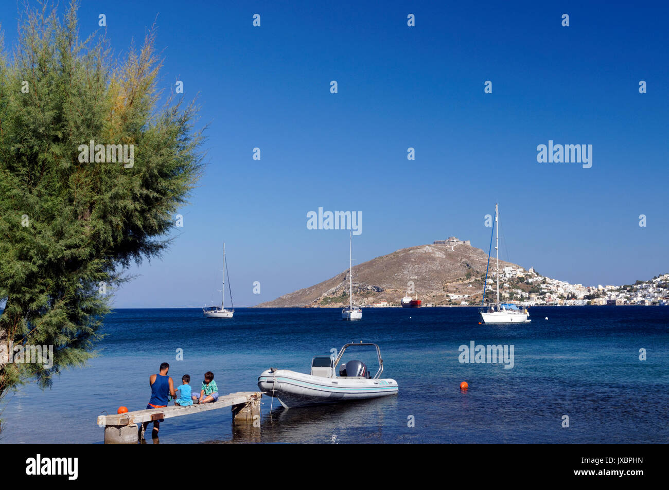 Greek man teaching sons how to fish, Alinta, Leros, Dodecanese Islands ...