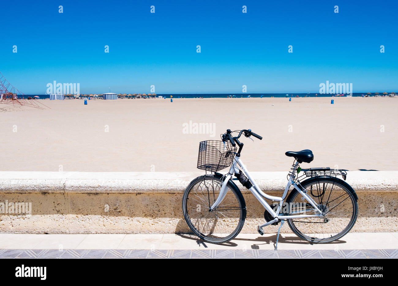 a bicycle parked in the seafront of the popular La Malvarrosa beach, in ...