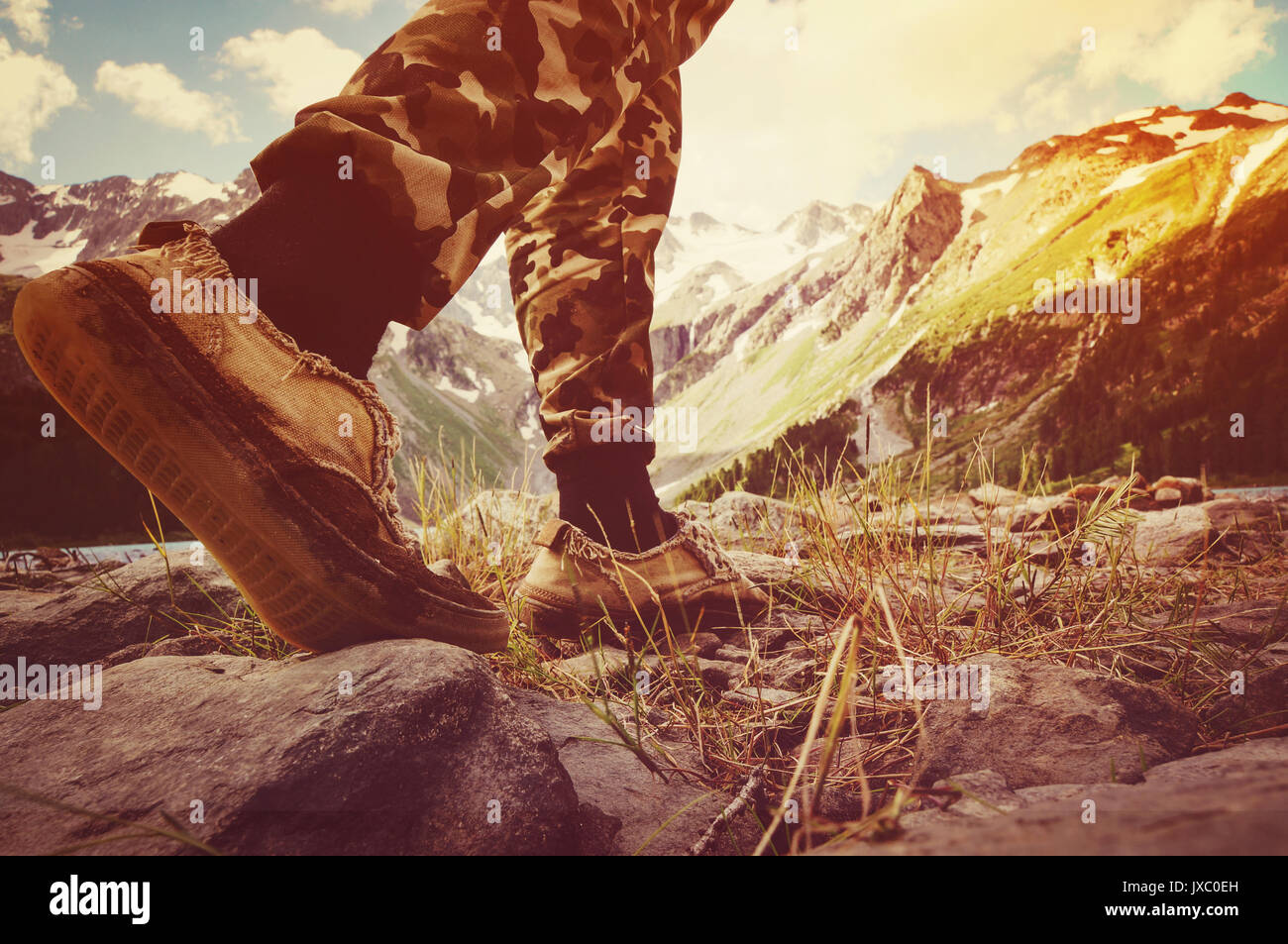 hikers go along mountain ridge. Leg tourist in sneakers walking on ...
