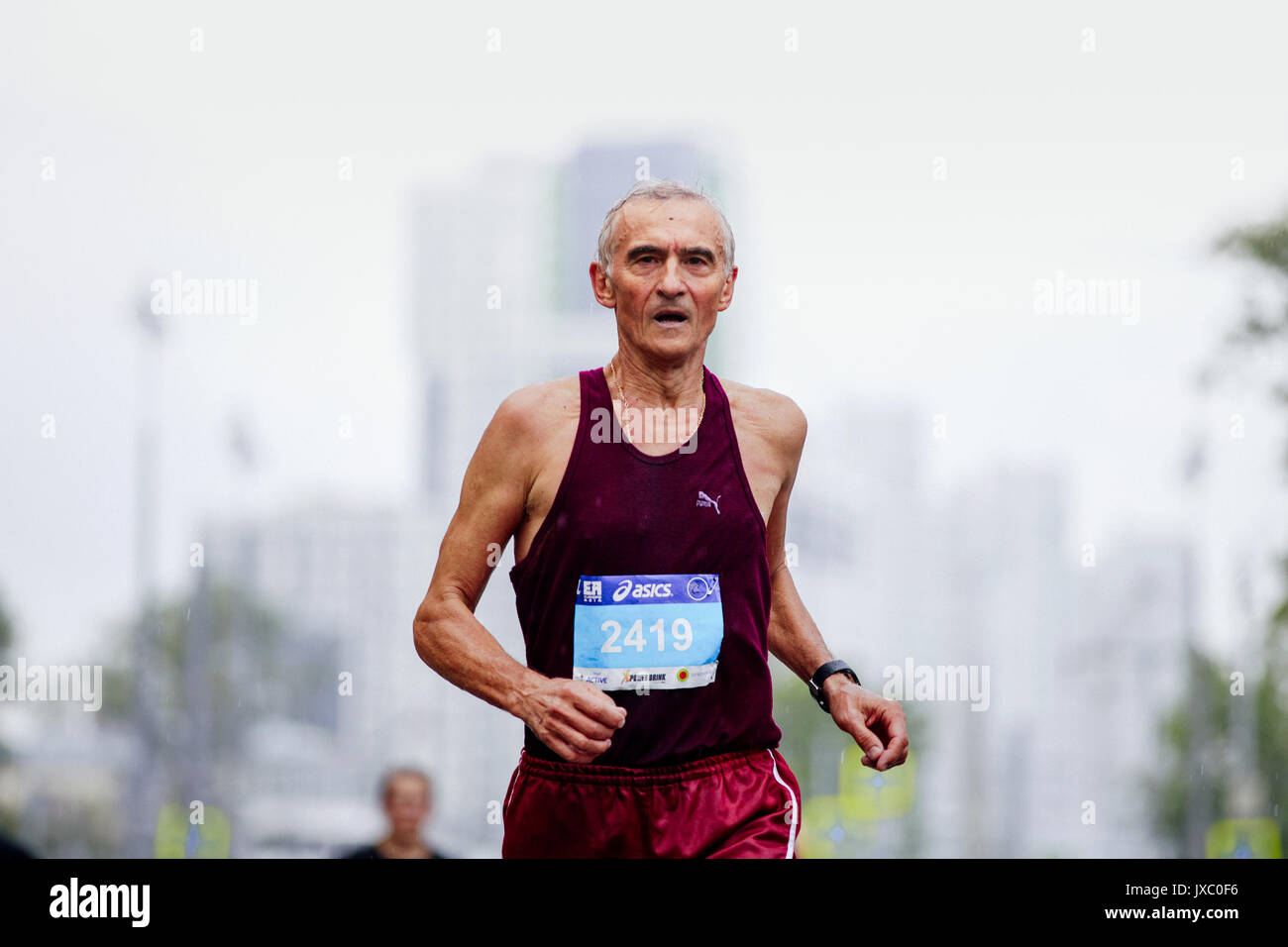elderly man runner running on city streets in Europe-Asia Marathon ...
