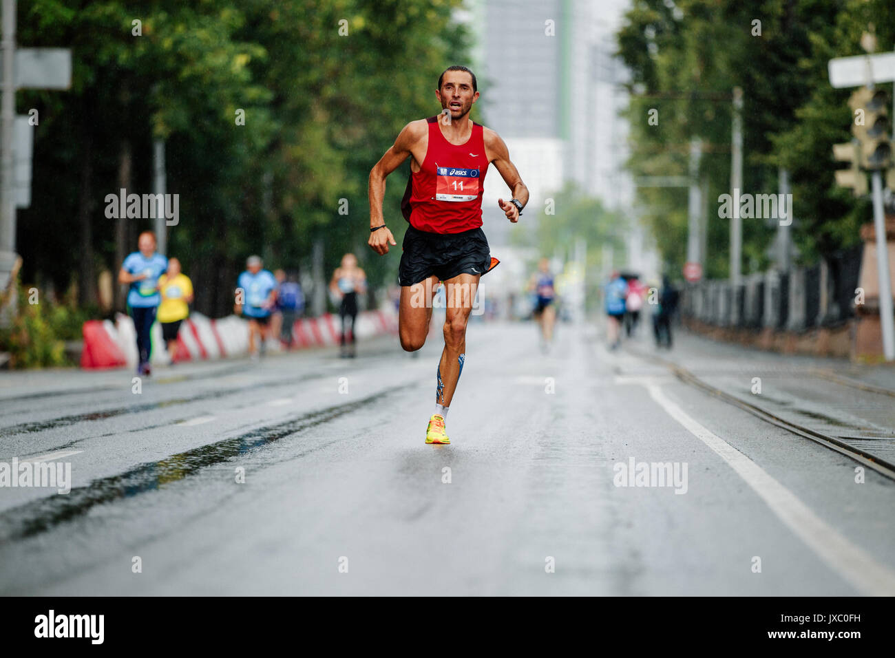 runner leader of marathon running street in rain during Europe-Asia ...
