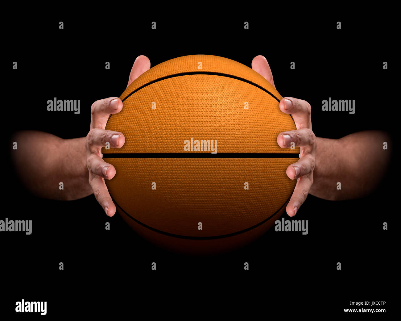 A pair of male hands clamping a basketball on an isolated dark ...