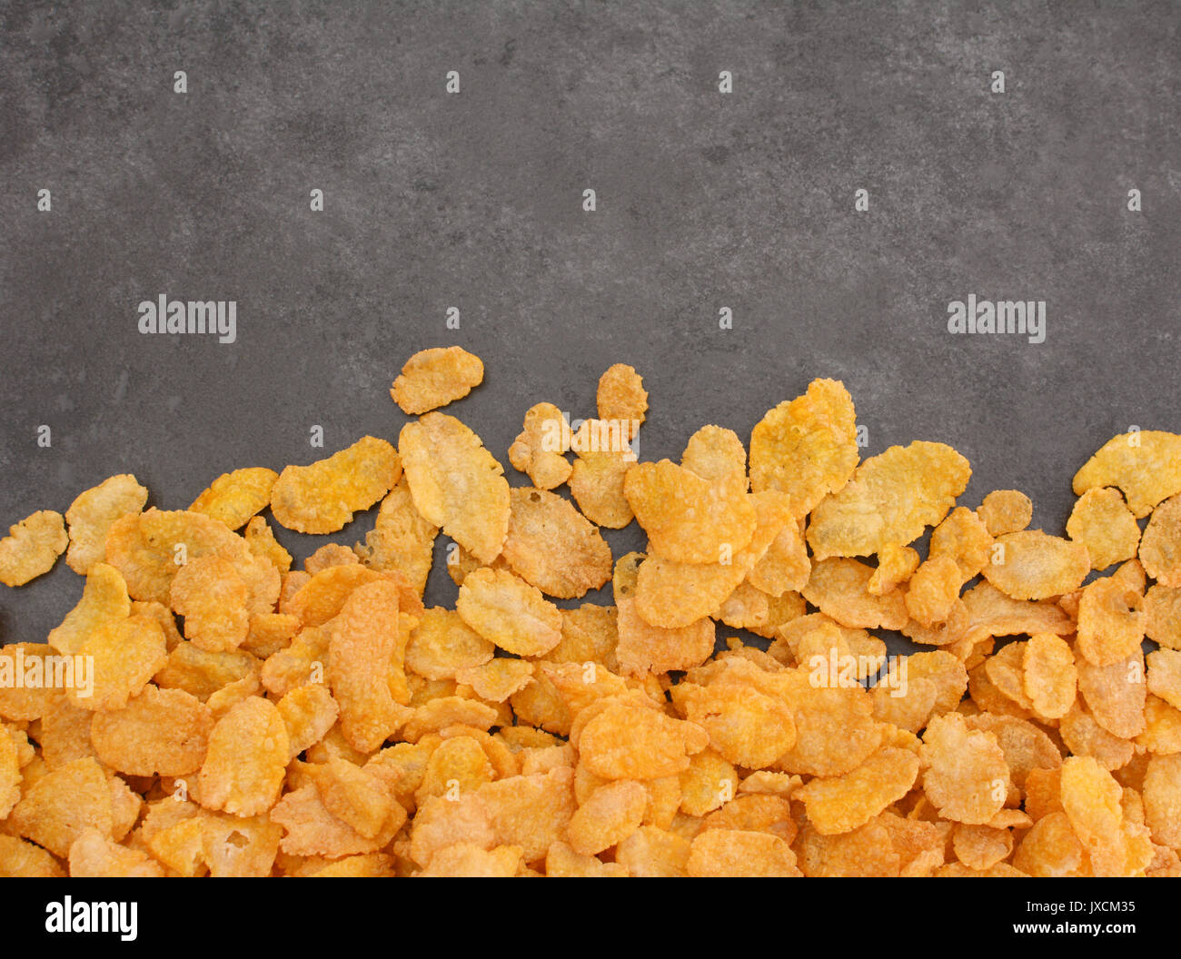 Corn flakes breakfast cereal in a border line with copy space on a dark ...