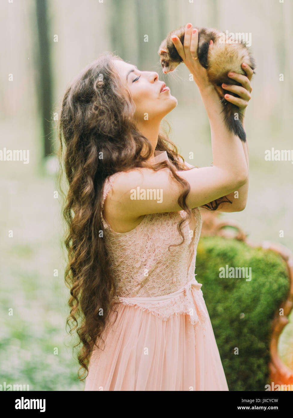 The close-up side portrait of the woman with long curly hair holding ...