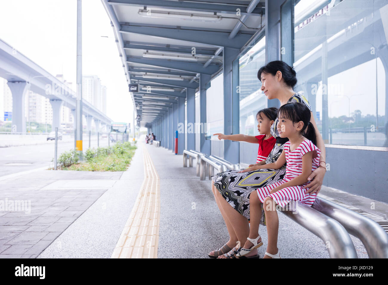 Chinese woman waiting bus stop hi-res stock photography and images - Alamy