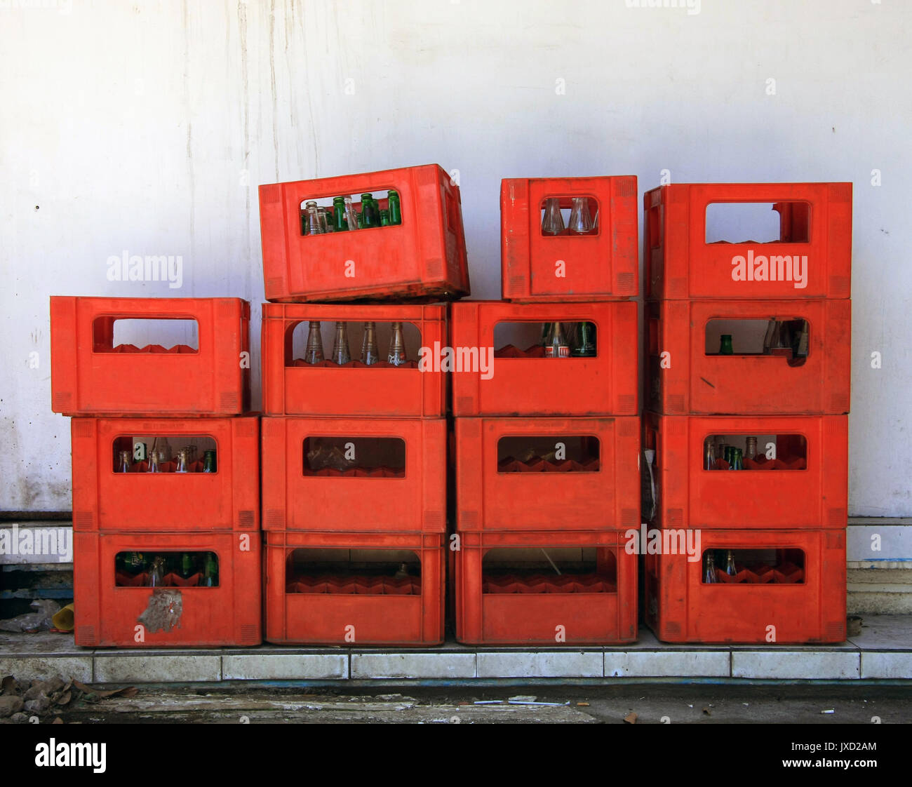 Stacked bottles in red plastic crates against a white wall Stock Photo ...