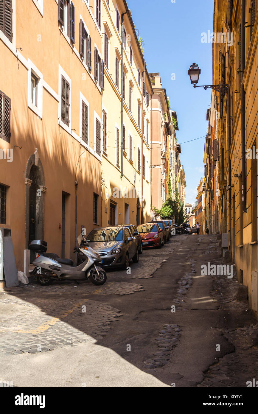 empty narrow picturesque downtown street with cars, motorbike in hot ...