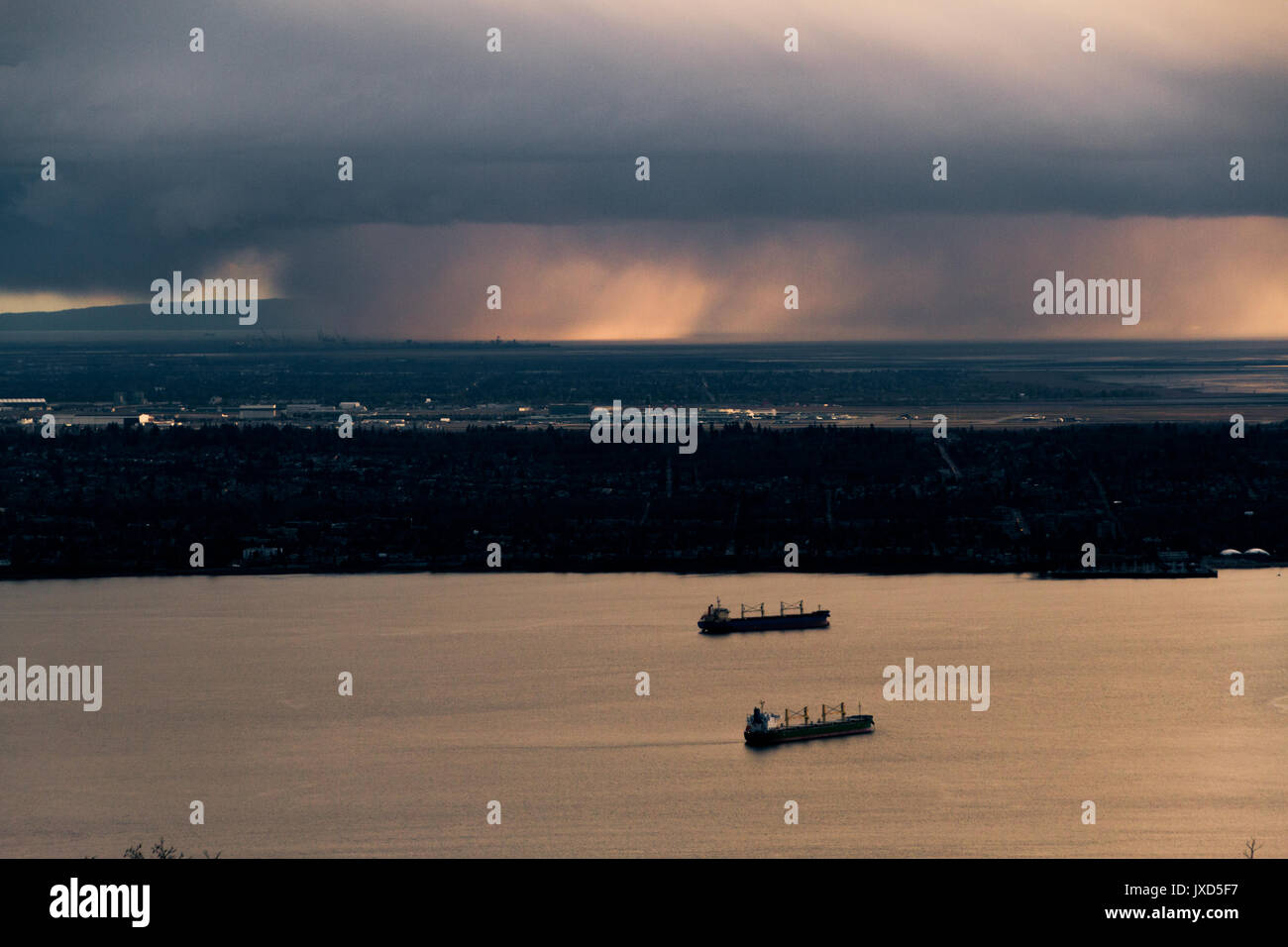 Ocean with cargo ships and rain from clouds Stock Photo - Alamy