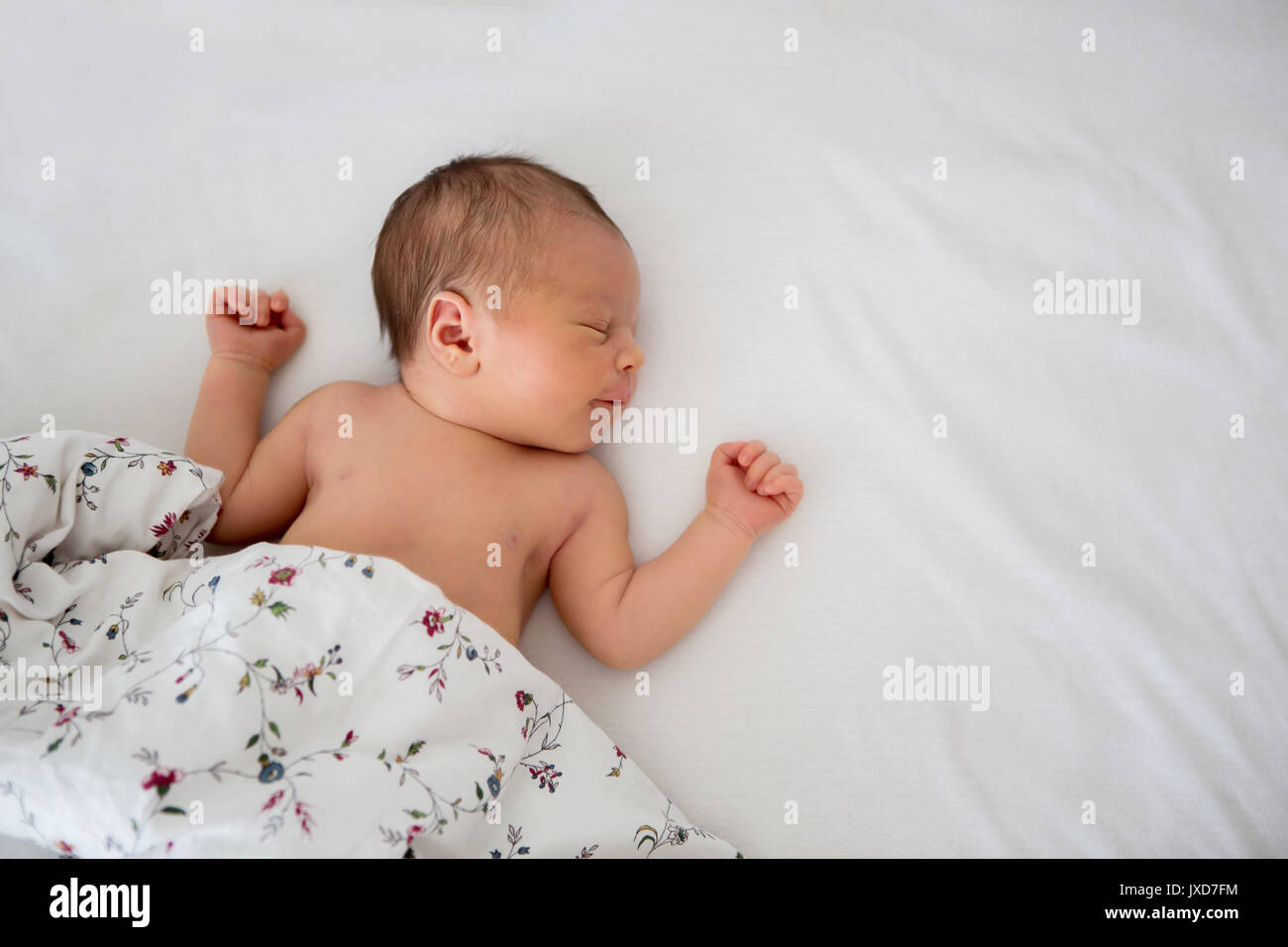 Beautiful newborn baby boy in bed. Infant lying down in bed. Healthy ...