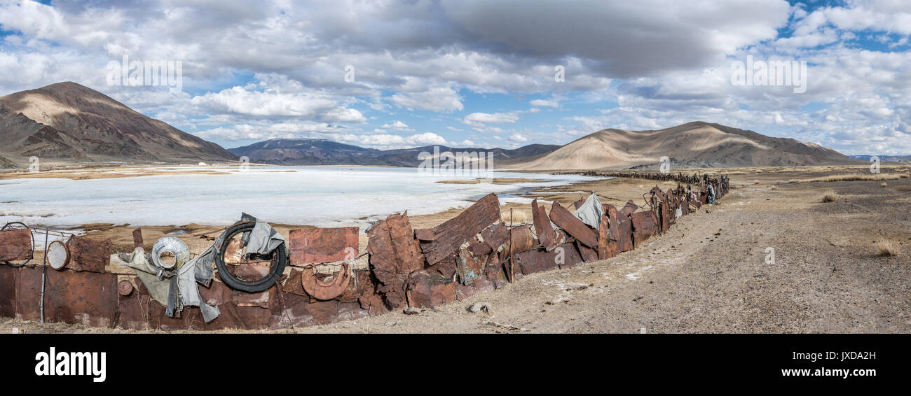 panoramic view of cold lake surrounded by fence of old rusty things ...