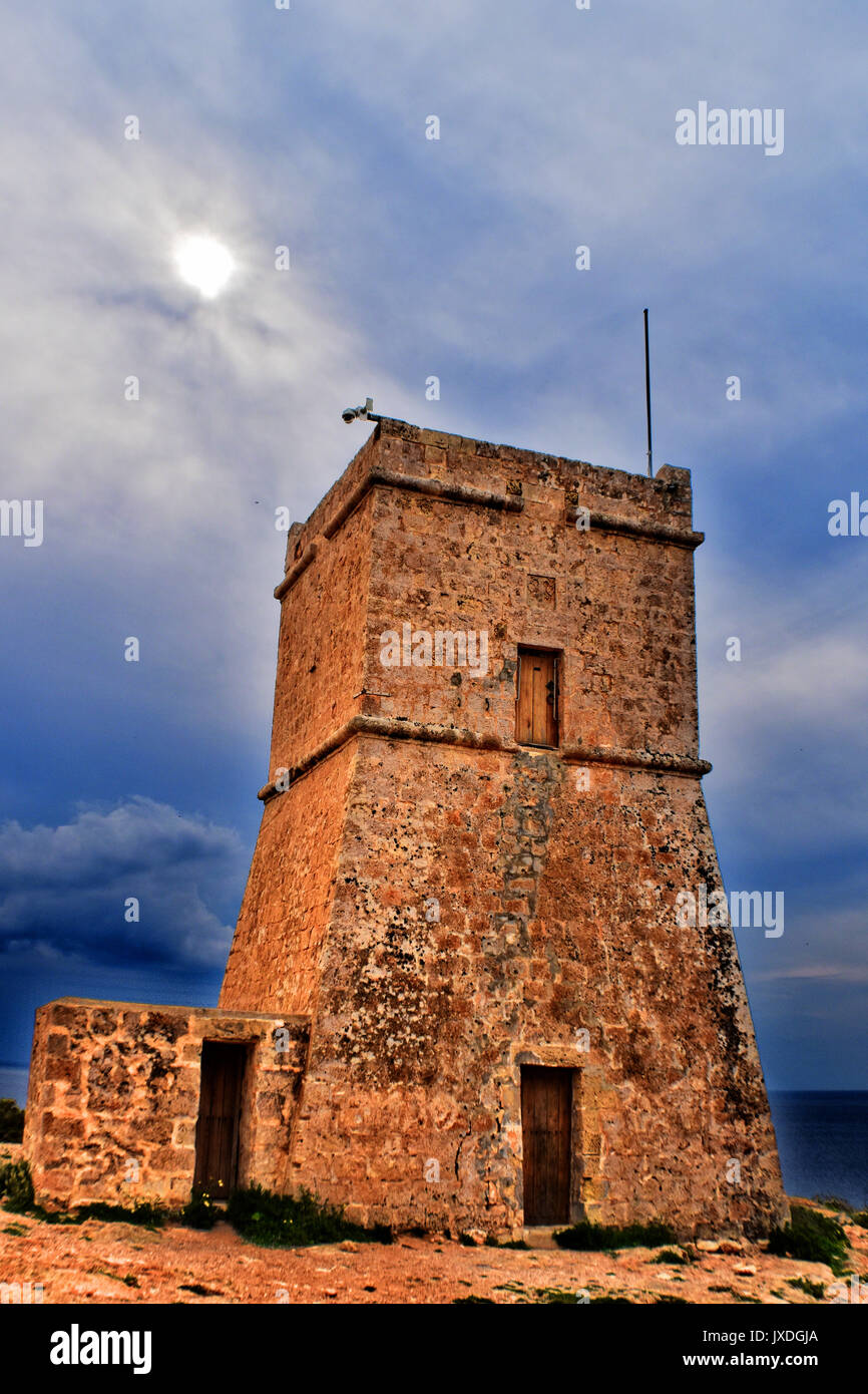 Ancient Guard Tower in Malta with stormy clouds and sun shining through ...