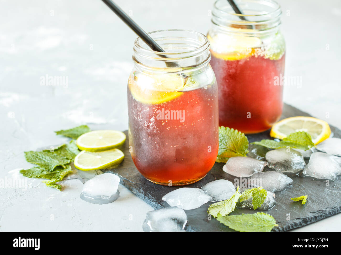 Summer ice tea with lemon, lime, mint and ice Stock Photo - Alamy