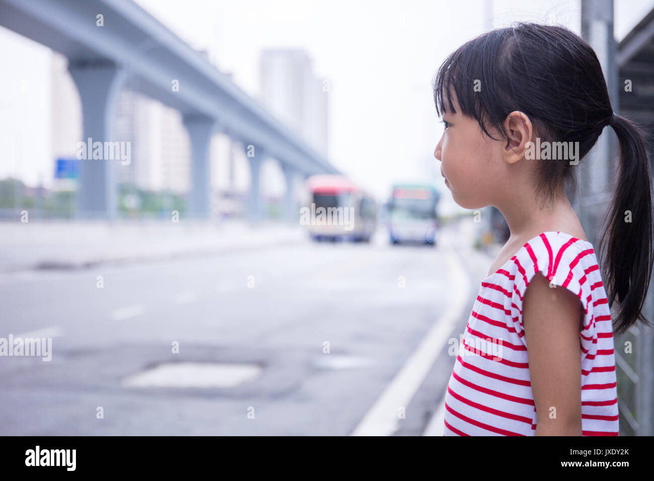 Asian Chinese little girl waiting for a bus at bus stop Stock Photo - Alamy