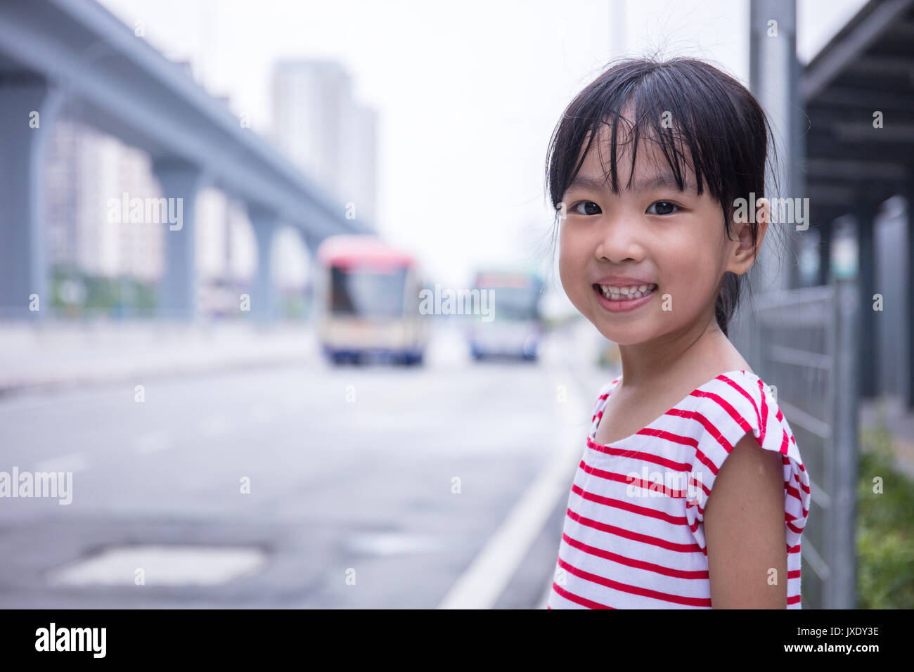 Asian Chinese little girl waiting for a bus at bus stop Stock Photo - Alamy