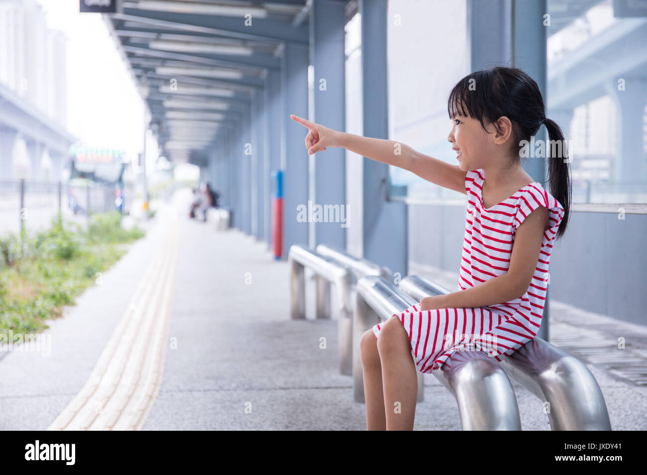 Asian Chinese little girl waiting for a bus at bus stop Stock Photo - Alamy