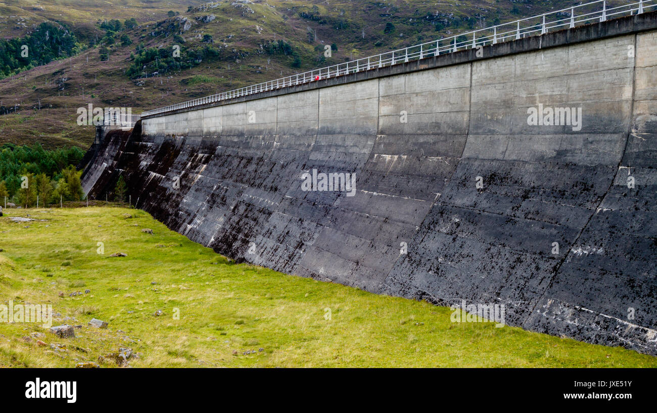 Concrete wall of hydroelectric dam with walkway and railings on top ...