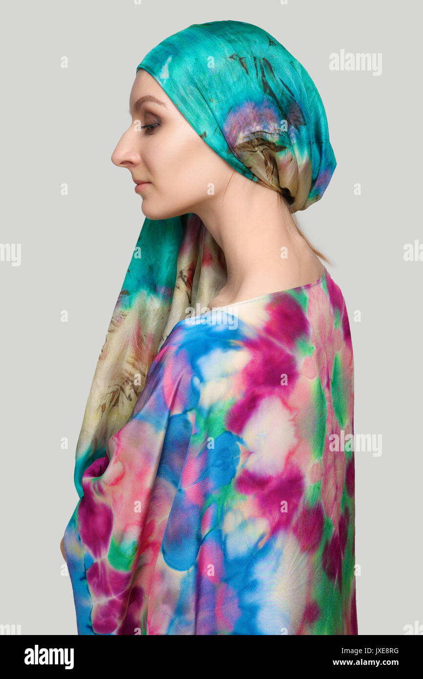 Pretty fashion model in colorful silk blouse and scarf wrapped around ...