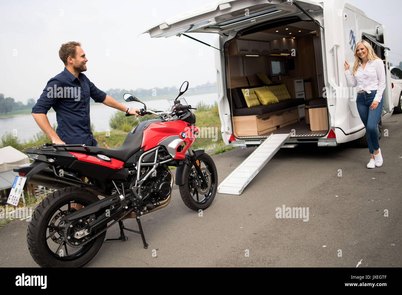 Duesseldorf, Germany. 16th Aug, 2017. Model Stefan pushes a motorbike ...