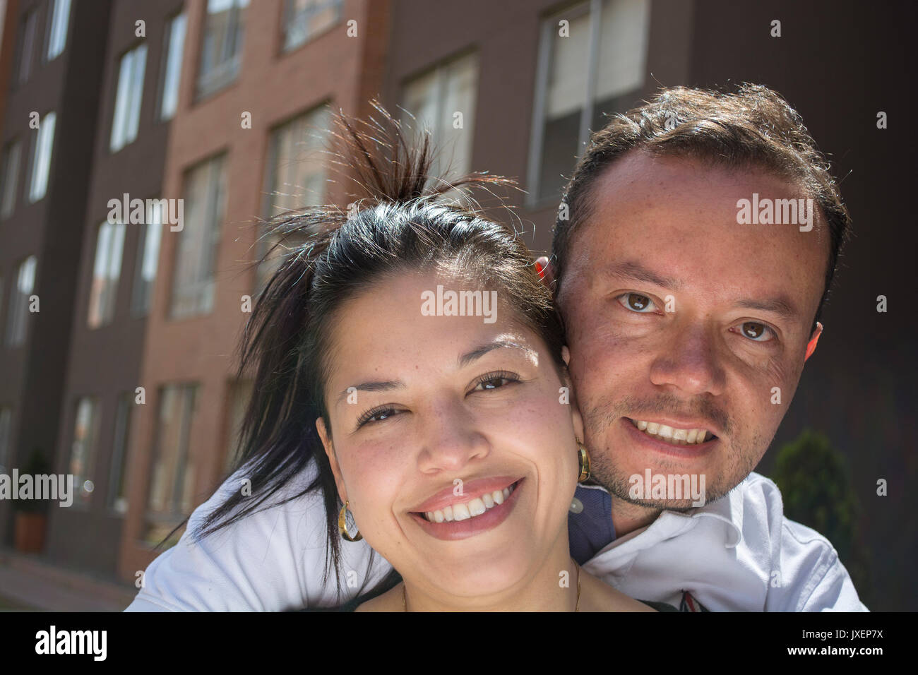 Attractive, very happy young couple embracing and smiling Stock Photo ...