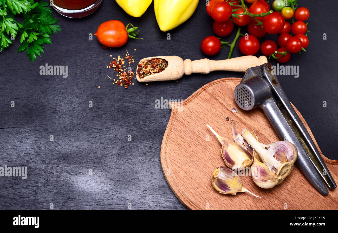 Fresh vegetables and garlic in the husk on a kitchen cutting board with ...