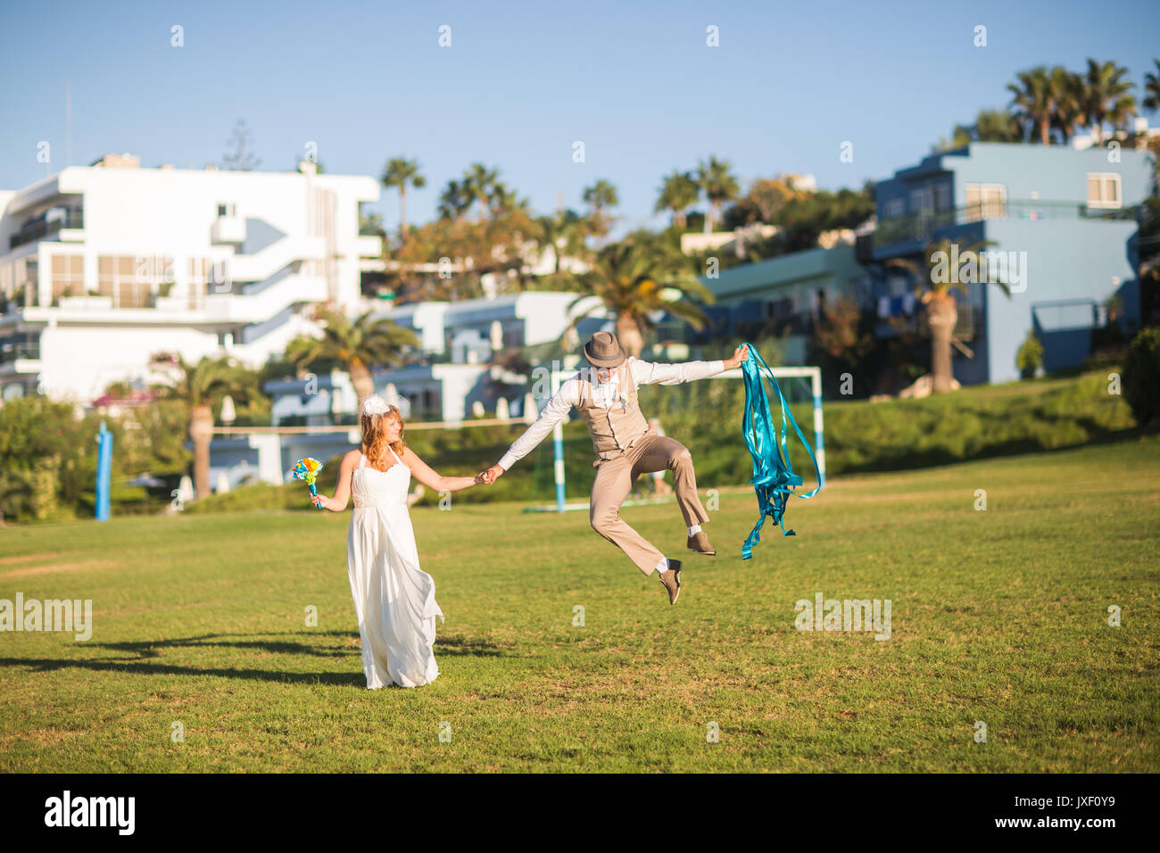 Happy bride and groom on their wedding jumping Stock Photo - Alamy
