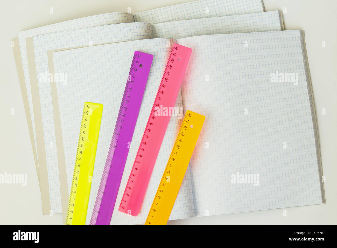 Close-up of a set of colored rulers on a background of large open blank ...