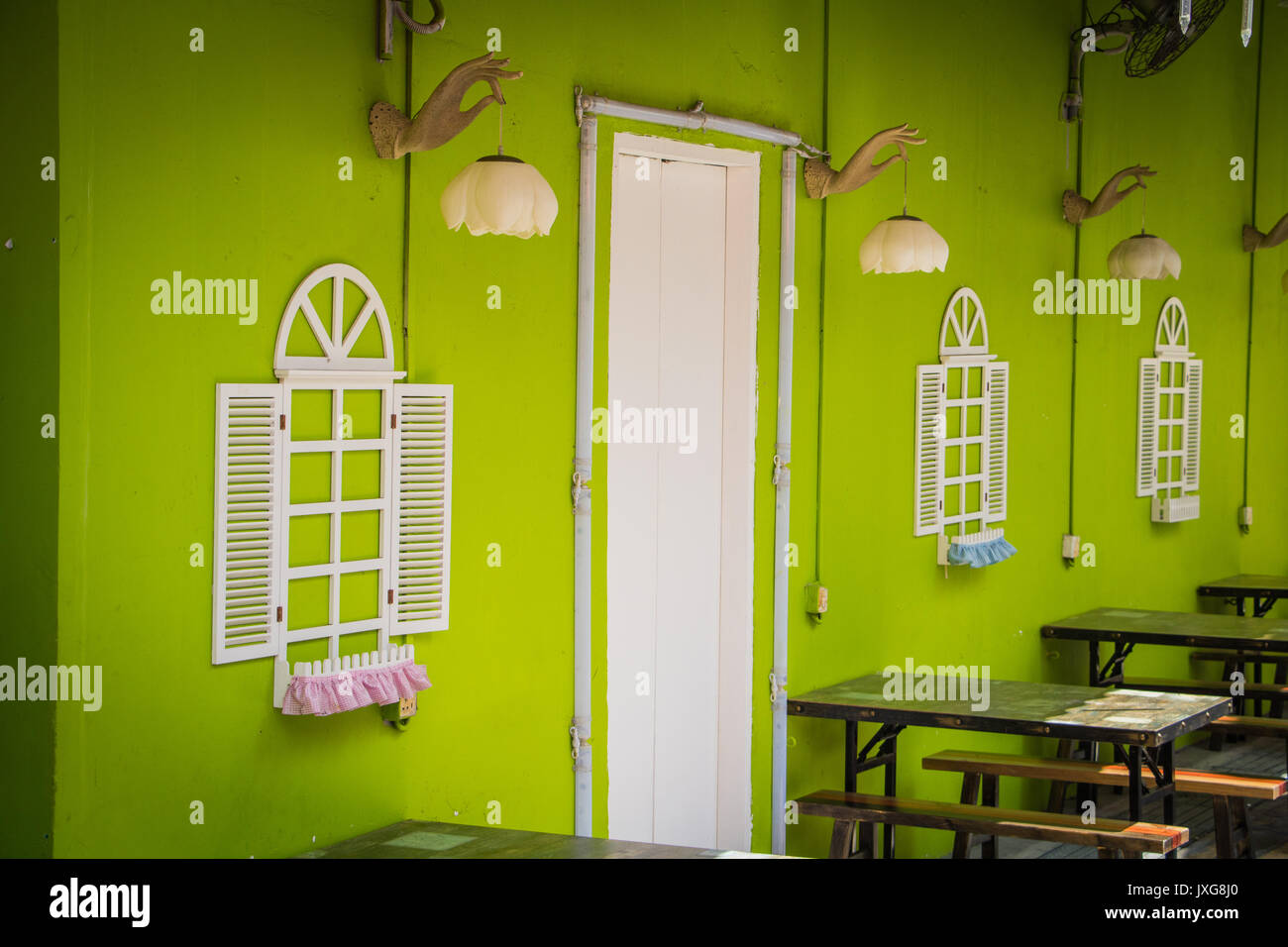 Lime green feature wall with decorative shutters Stock Photo - Alamy