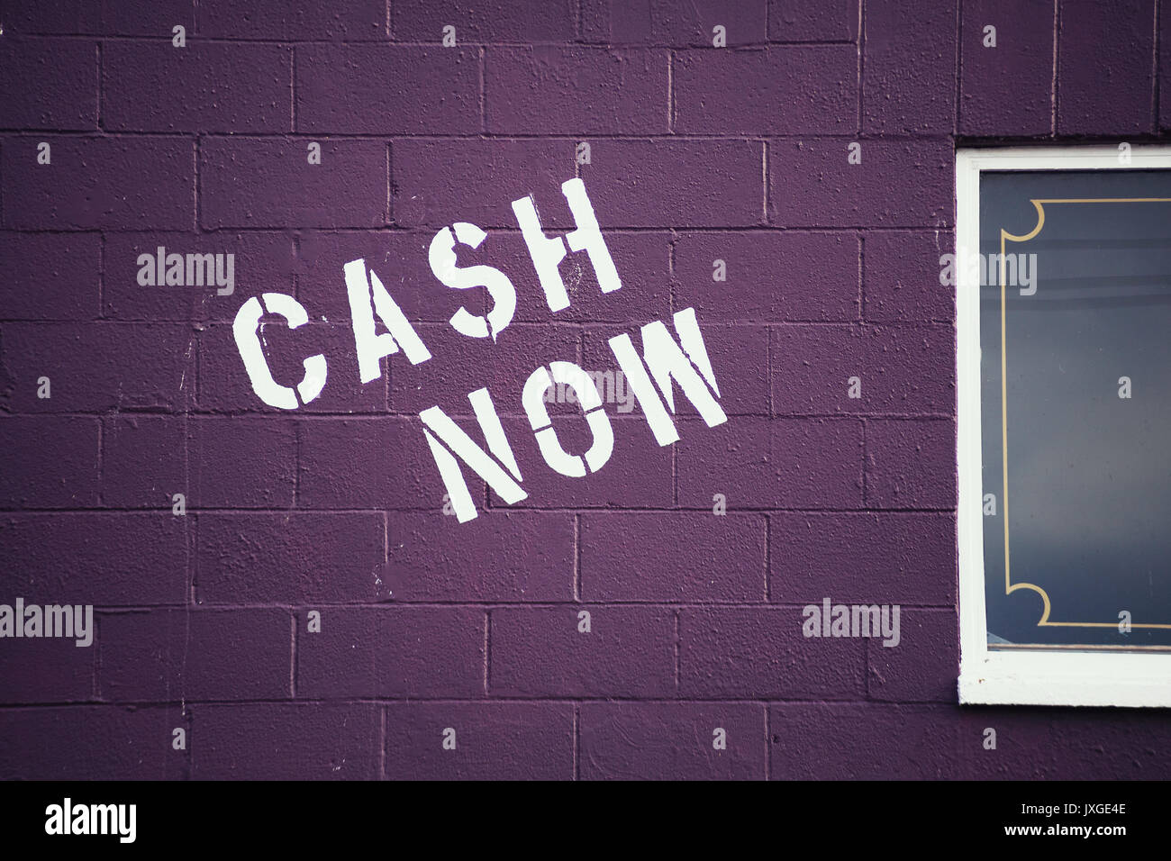 Cash Now sign on concrete wall Stock Photo - Alamy