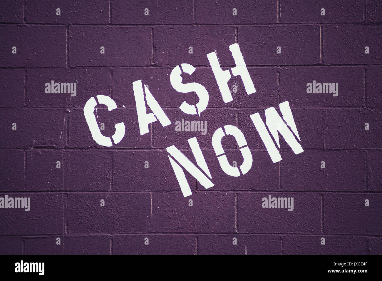 Cash Now sign on concrete wall Stock Photo - Alamy