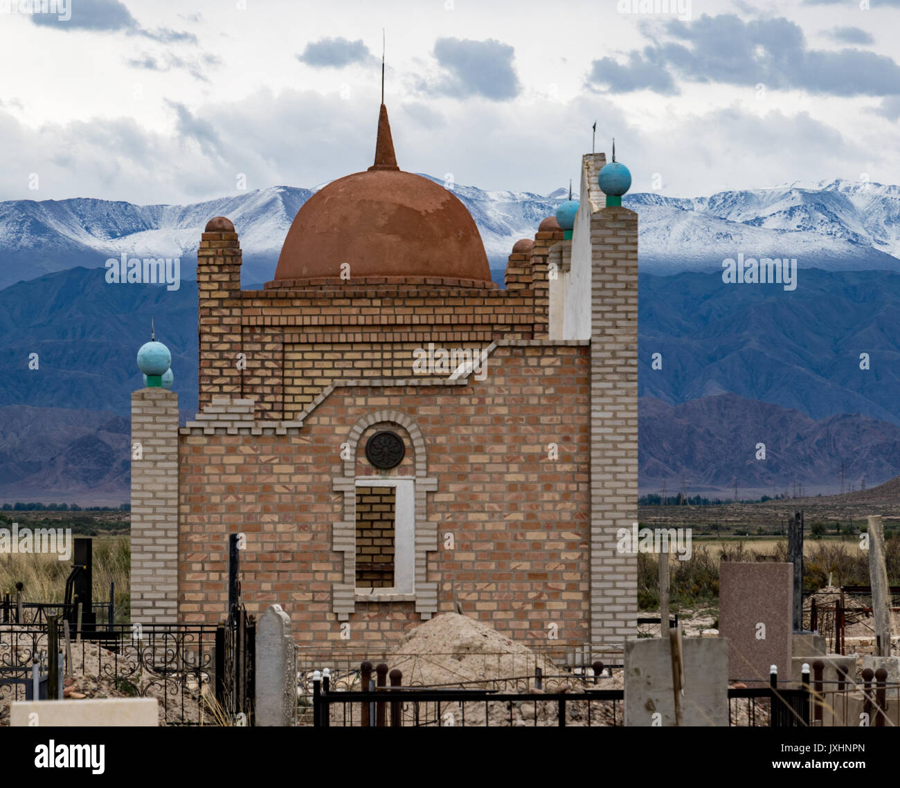 Islamic Mausoleum with snow capped mountains in background Stock Photo ...