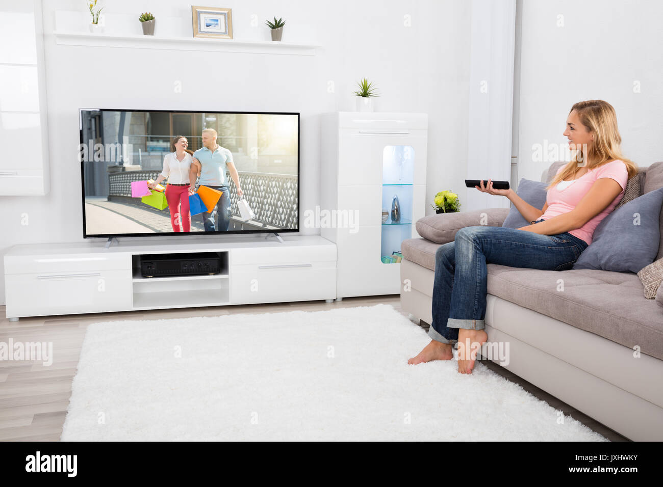 Young Happy Woman Sitting On Couch Watching Romantic Movie On ...