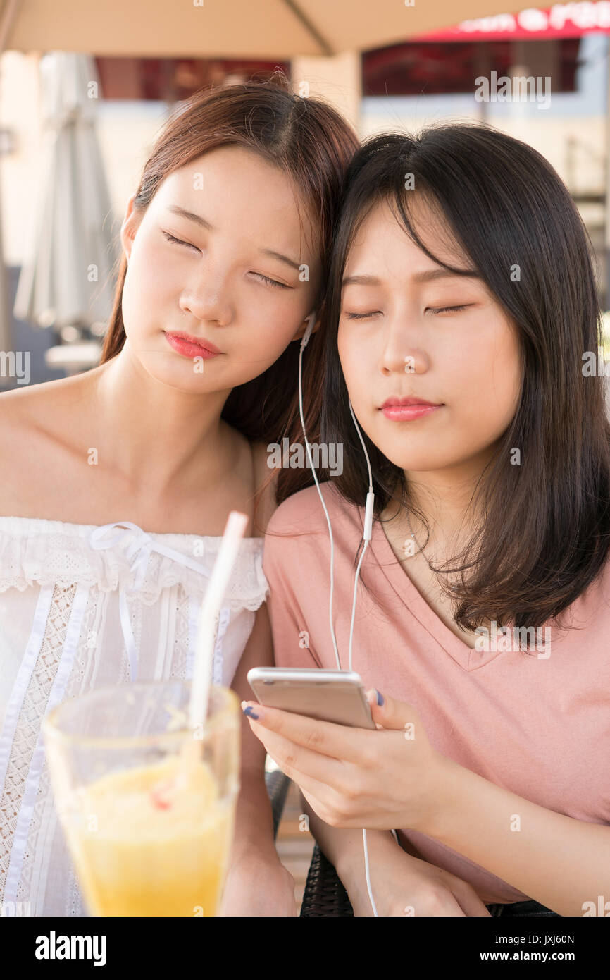 two girls listening music Stock Photo - Alamy