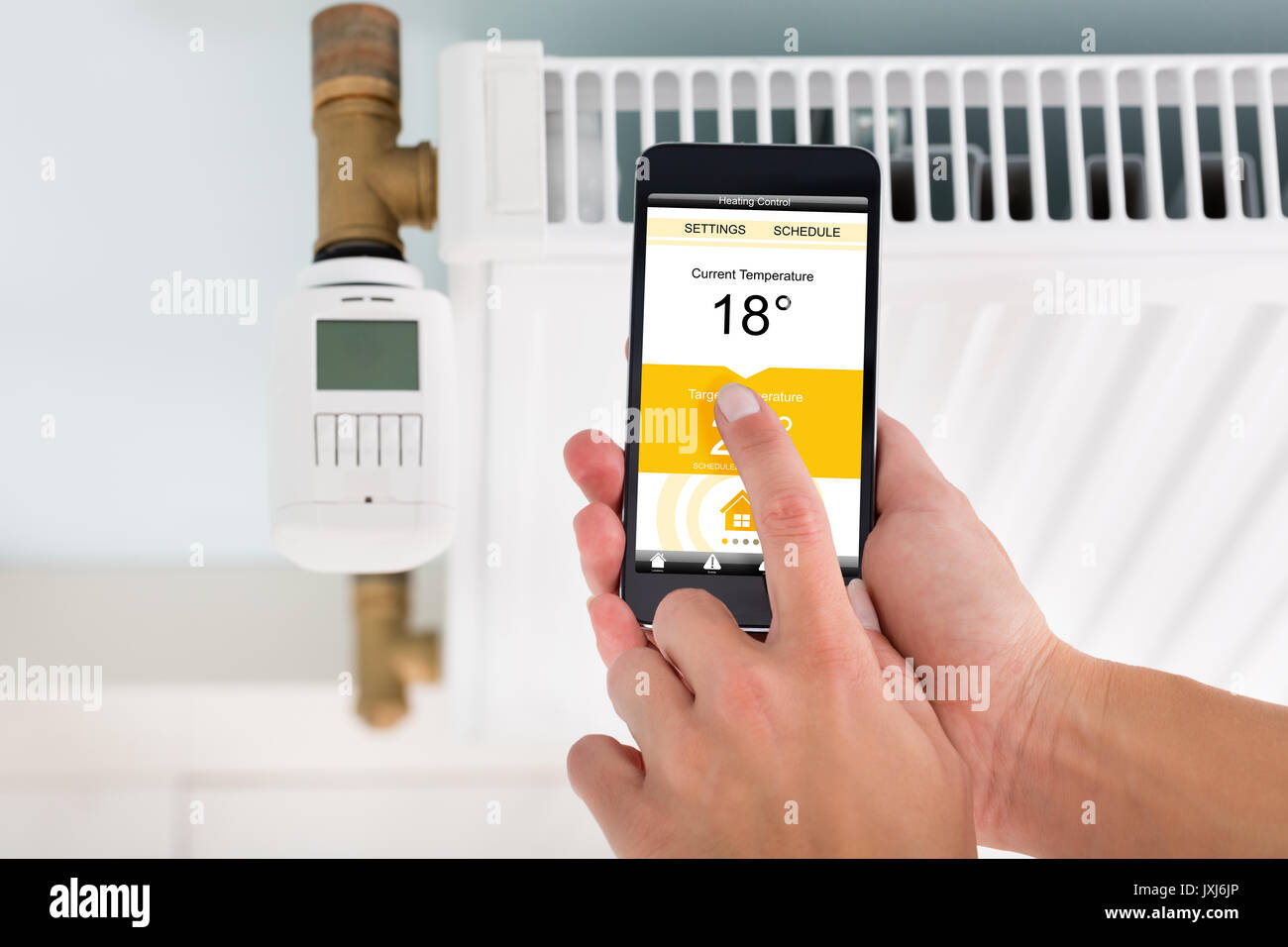 Person's Hand Adjusting Temperature Of Digital Smart Thermostat Using ...