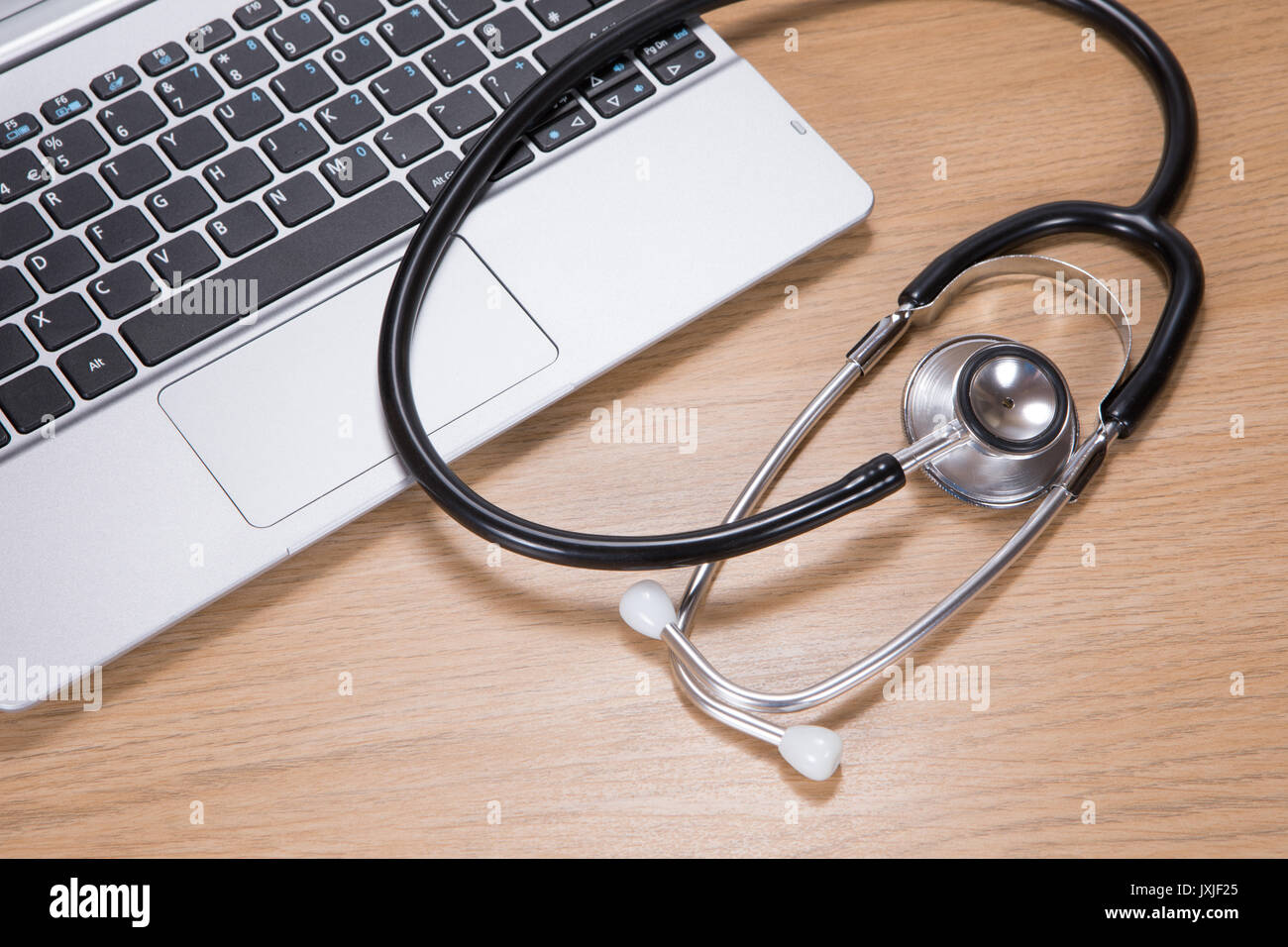 Stethoscope on a desk with a laptop computer in a concept of online ...
