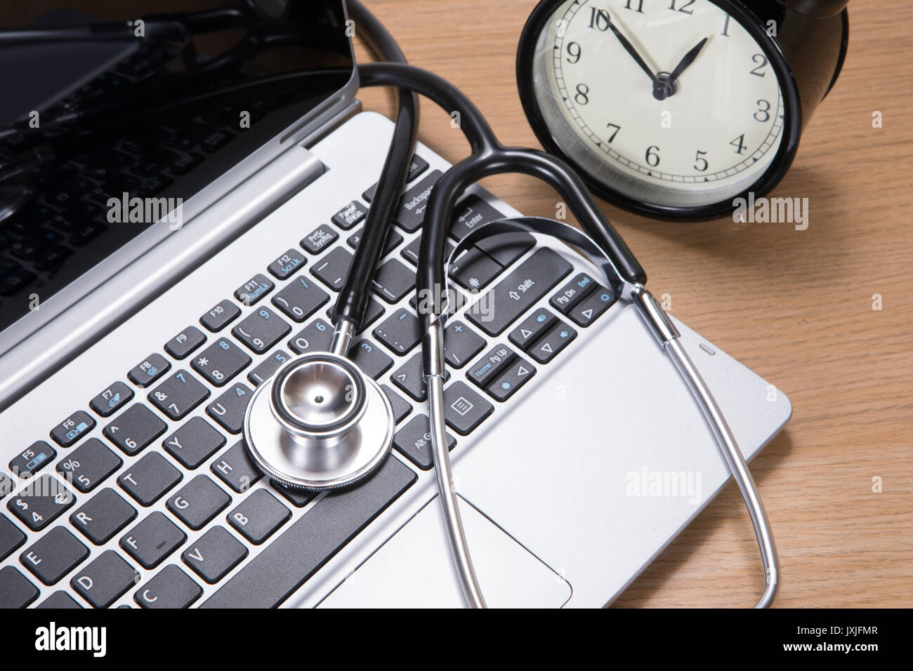 Angled close up of medical stethoscope on metal and plastic computer ...