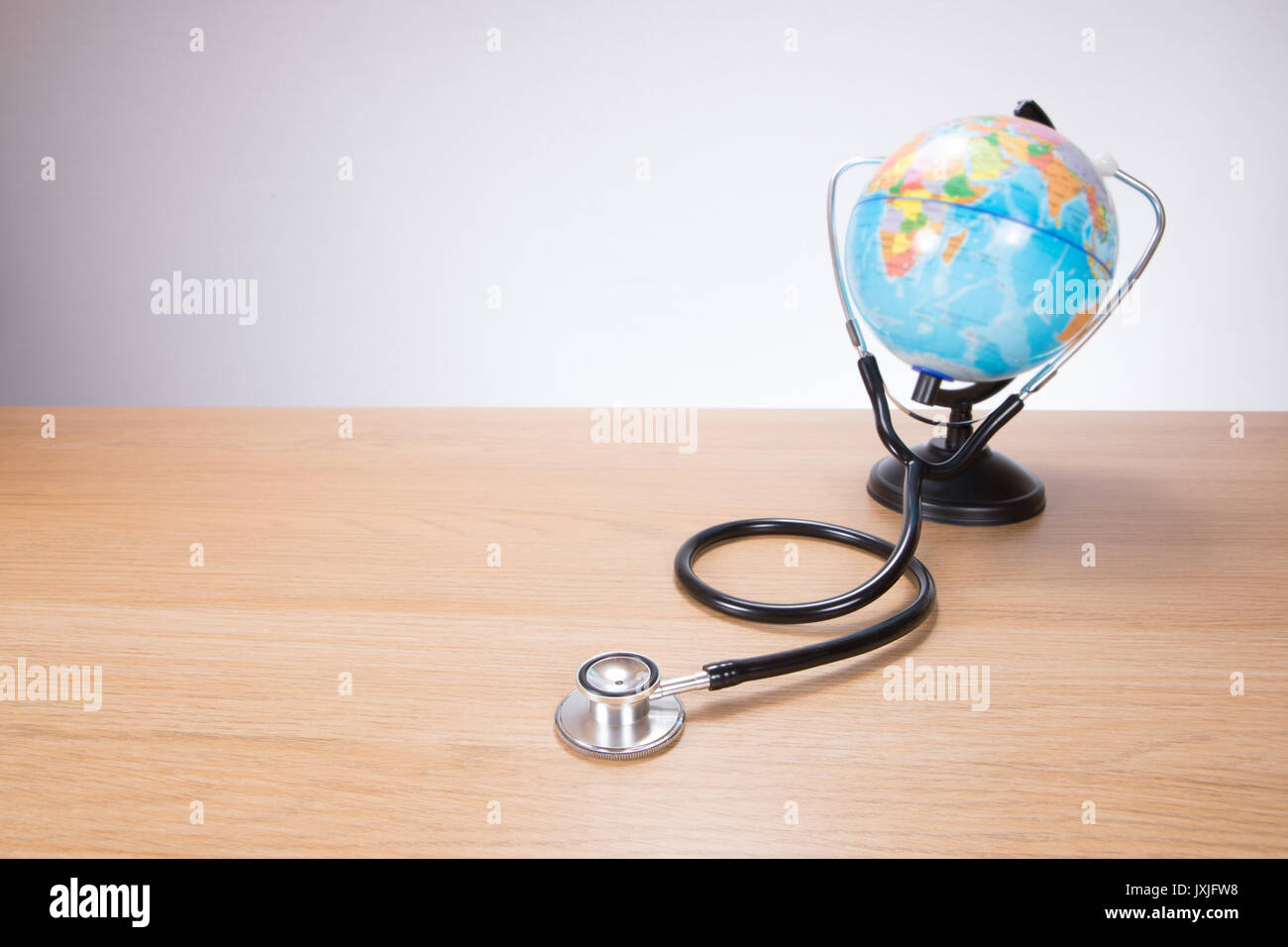 World globe with stethoscope on wood in a concept of saving the planet ...
