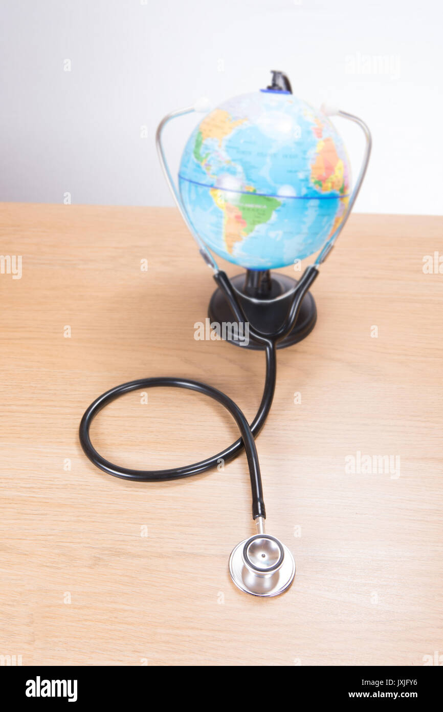 Stethoscope around a world globe in a concept of the state of health of ...