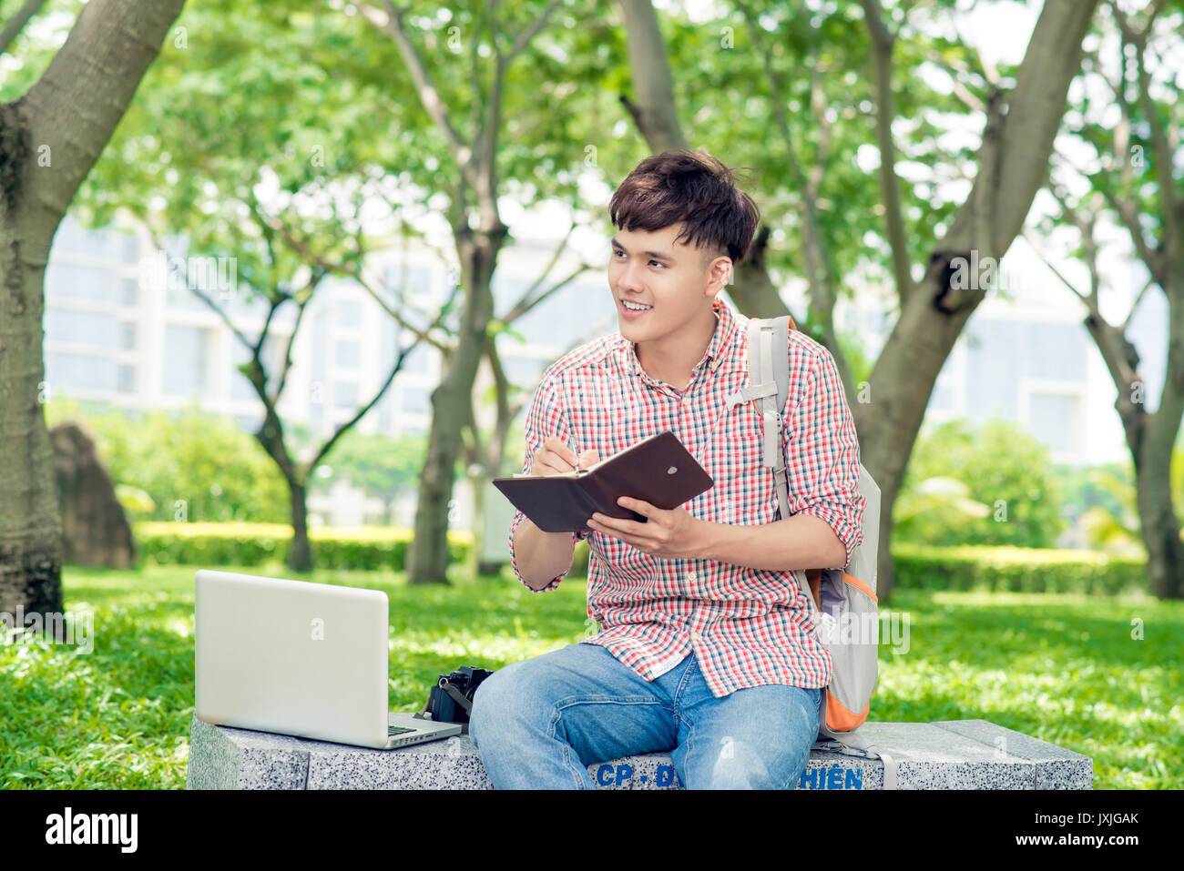 Asian student writing compositions in copybooks sitting in park Stock ...