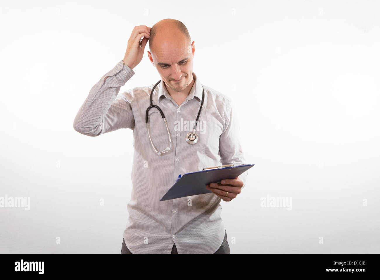 Puzzled doctor wearing a stethoscope around his neck scratching his ...