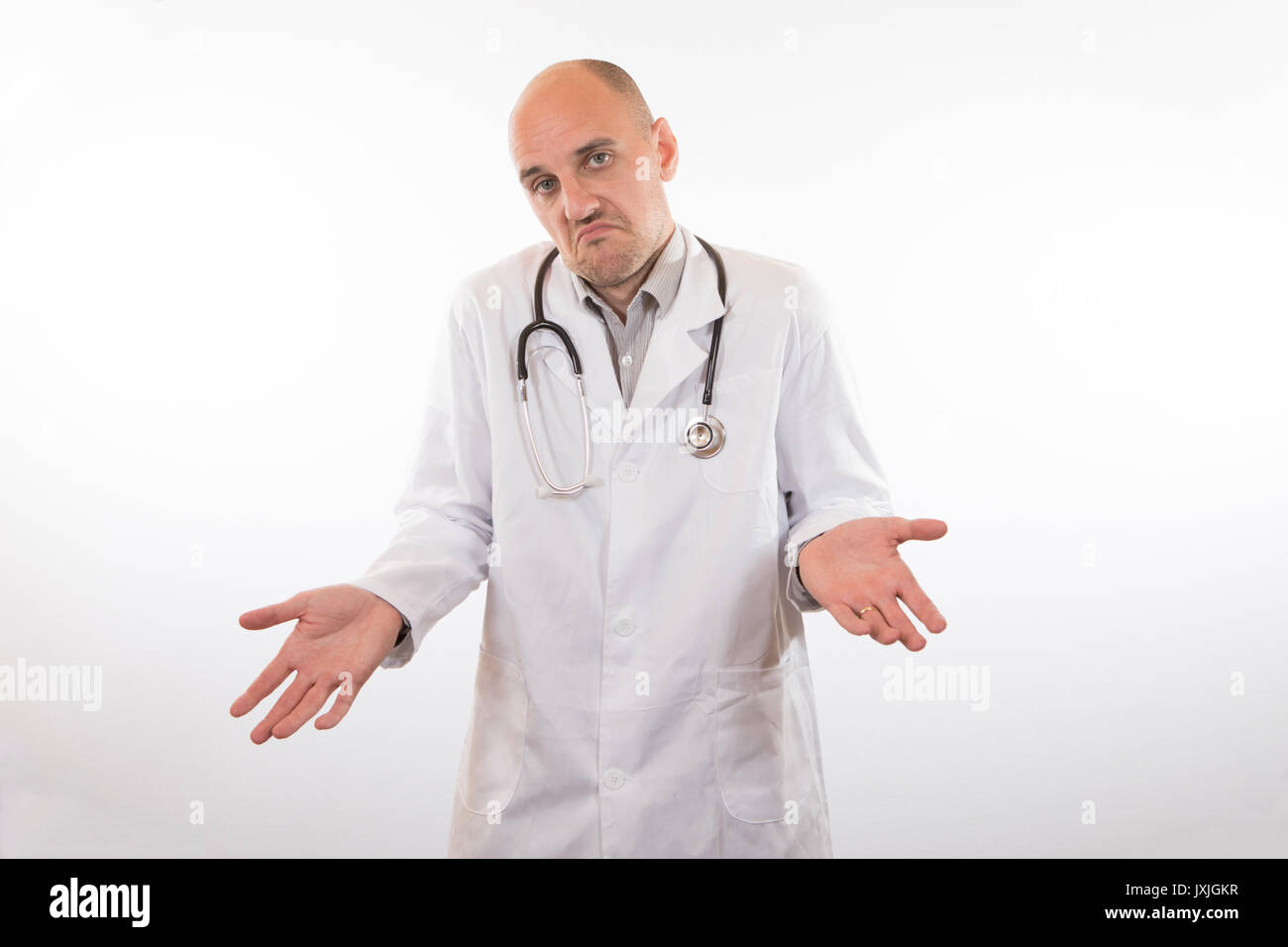 Puzzled mid adult male doctor wearing gown with stethoscope standing ...