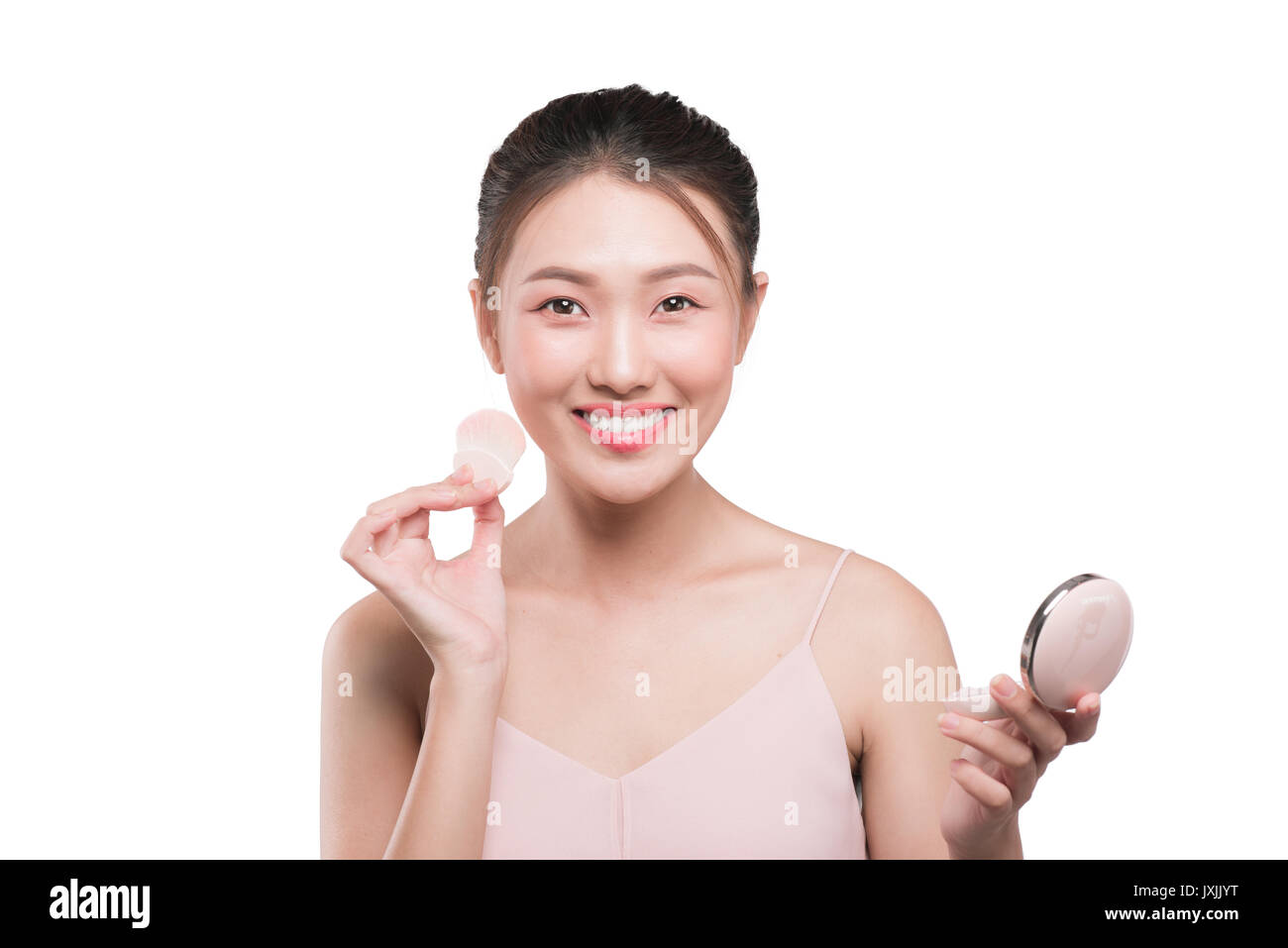 Portrait of beautiful young asian woman with perfect fresh clean applying blusher to her cheek ...