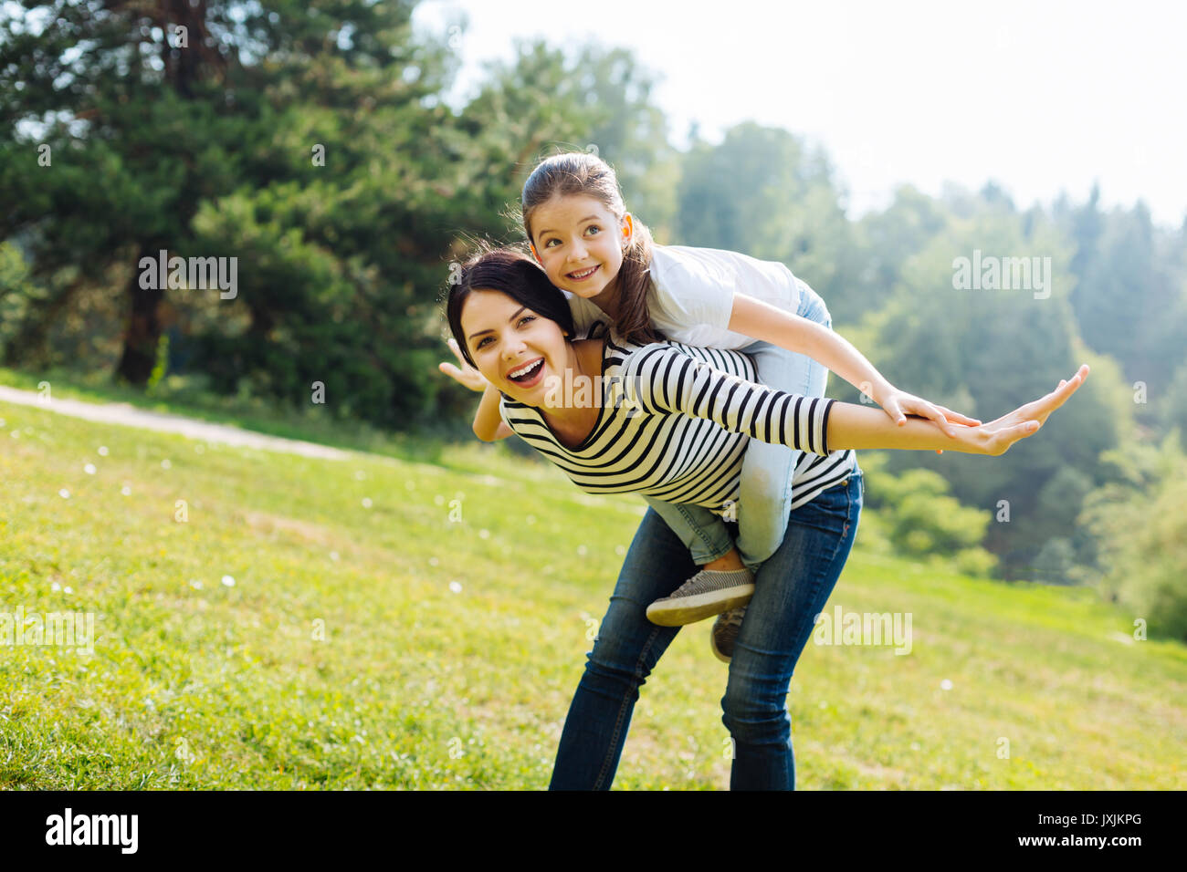 Happy mother giving a piggyback ride to her daughter Stock Photo - Alamy