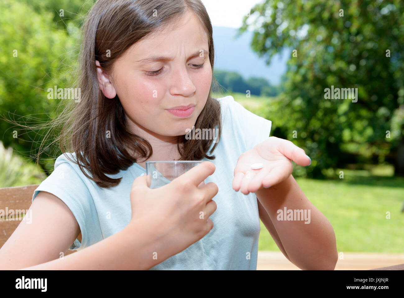 cute girl child taking pill with glass of water Stock Photo - Alamy