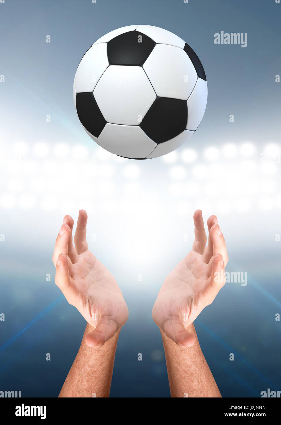 A pair of male hands reaching upwards to catch a soccer ball on a ...