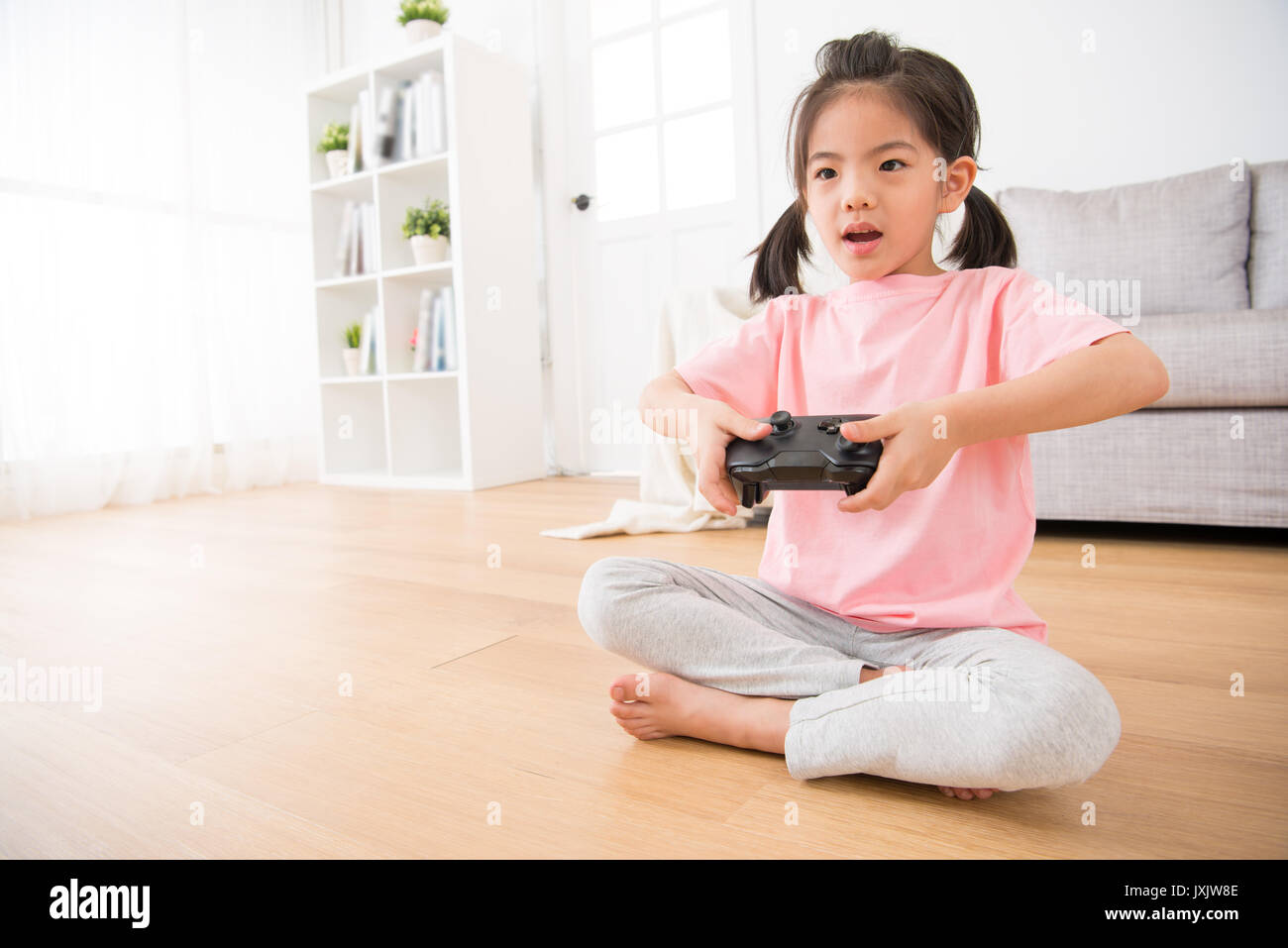 happy little daughter focus on using game joystick controller seriously ...