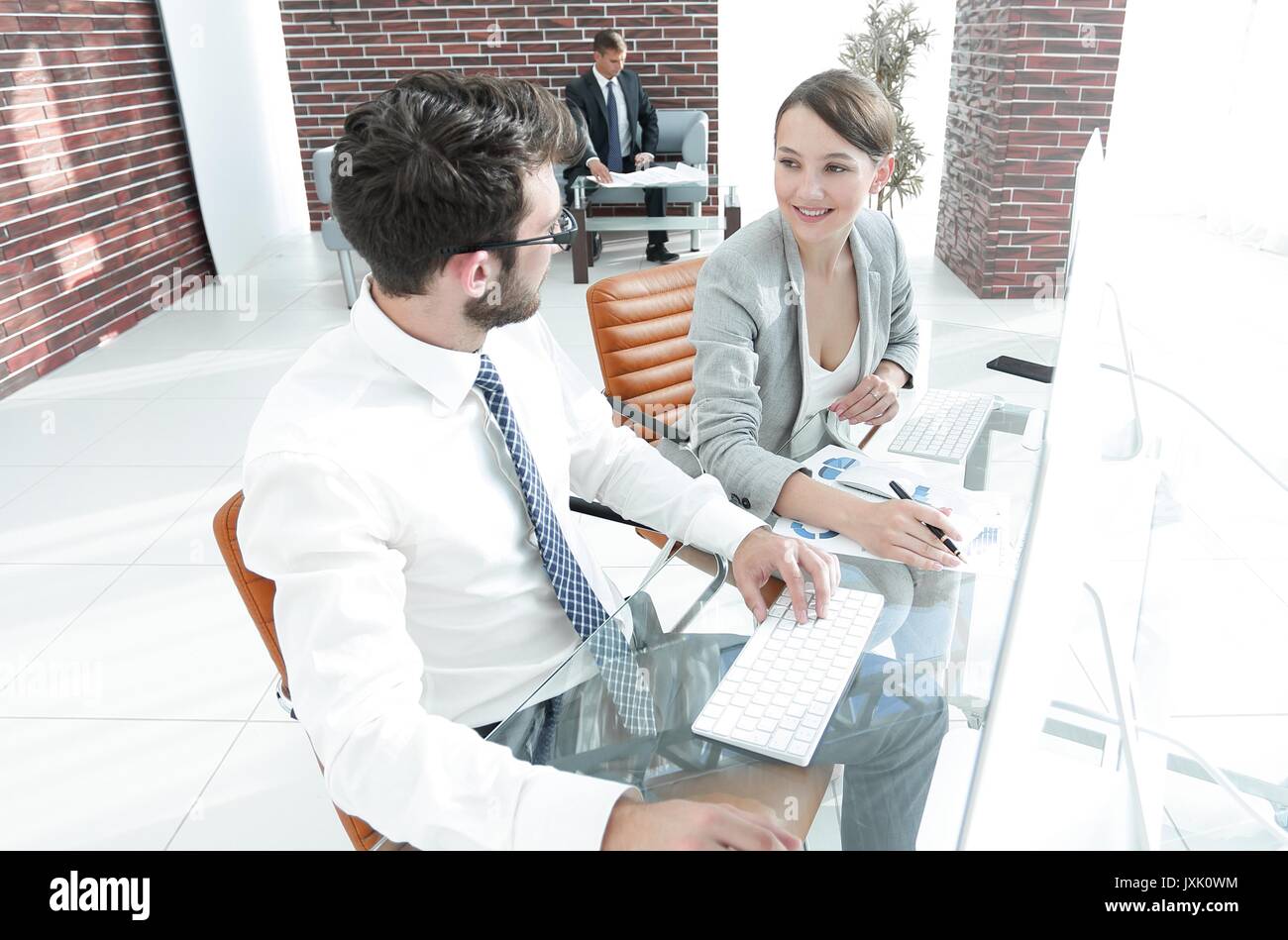 young professionals sitting behind a Desk Stock Photo - Alamy