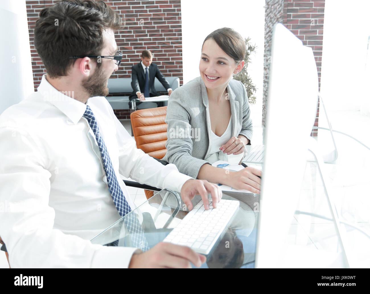 young professionals sitting behind a Desk Stock Photo - Alamy