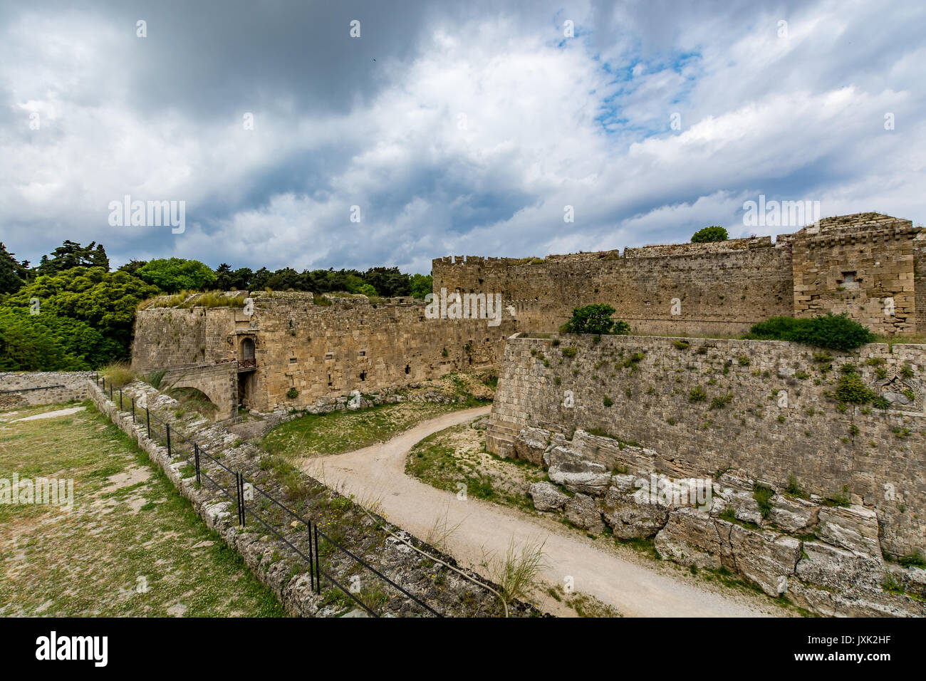 Medieval walls of Rhodes and moat under moody cloudy sky, Rhodes island ...
