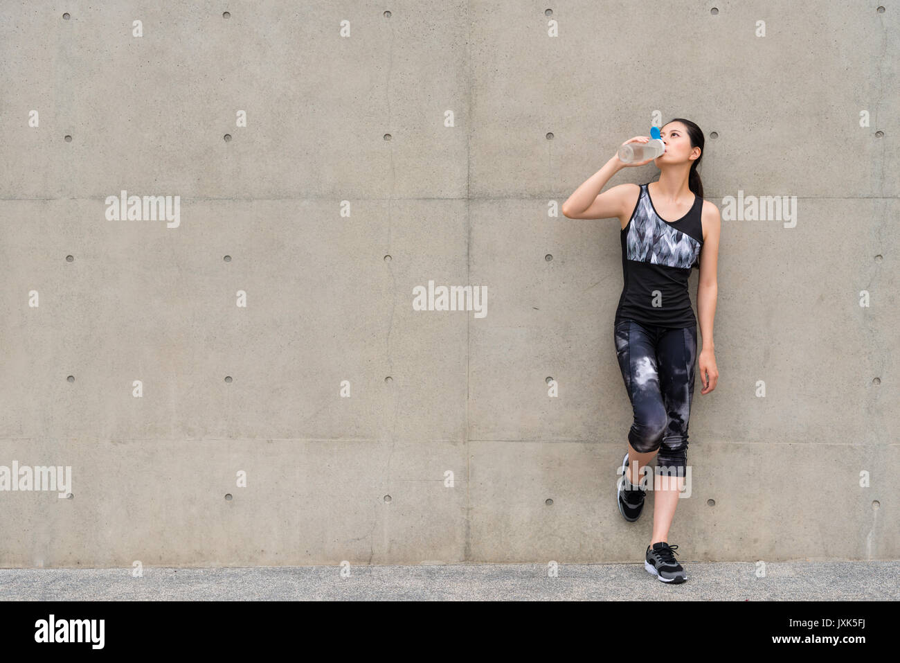 confident exercise woman drinking water after jogging and sweating and ...