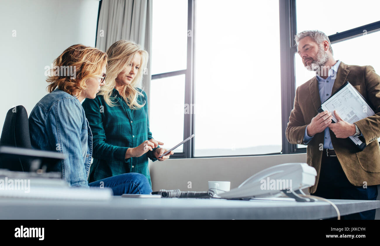 business woman explaining something to female coworker with a digital ...